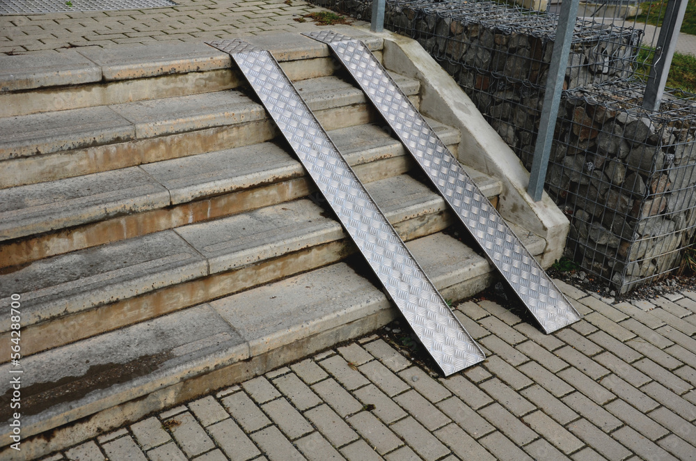 ramp combined with a gray concrete staircase and a handrail specially ...