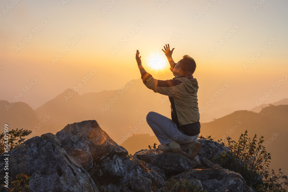 Young male kneeling down with hands open palm up praying to God on the ...