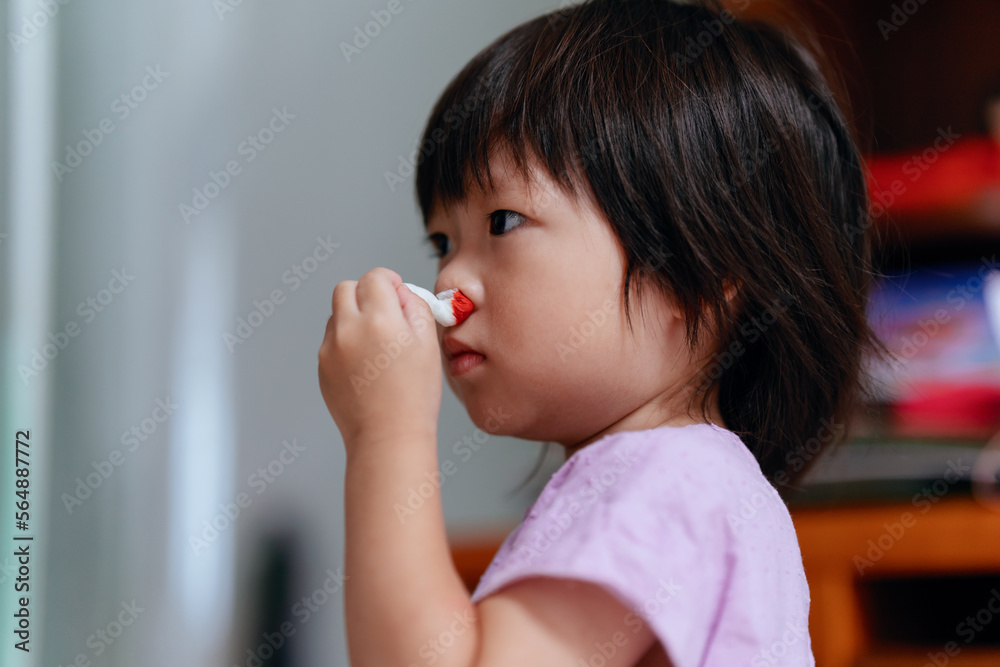 Child uses tissue to stop nosebleed Stock Photo | Adobe Stock