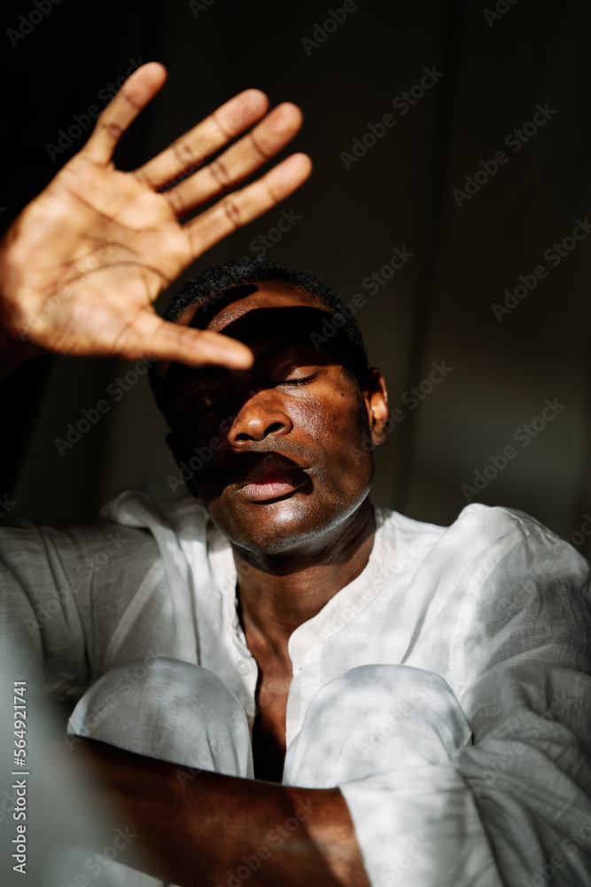 Man covering face from sun. Stock Photo | Adobe Stock