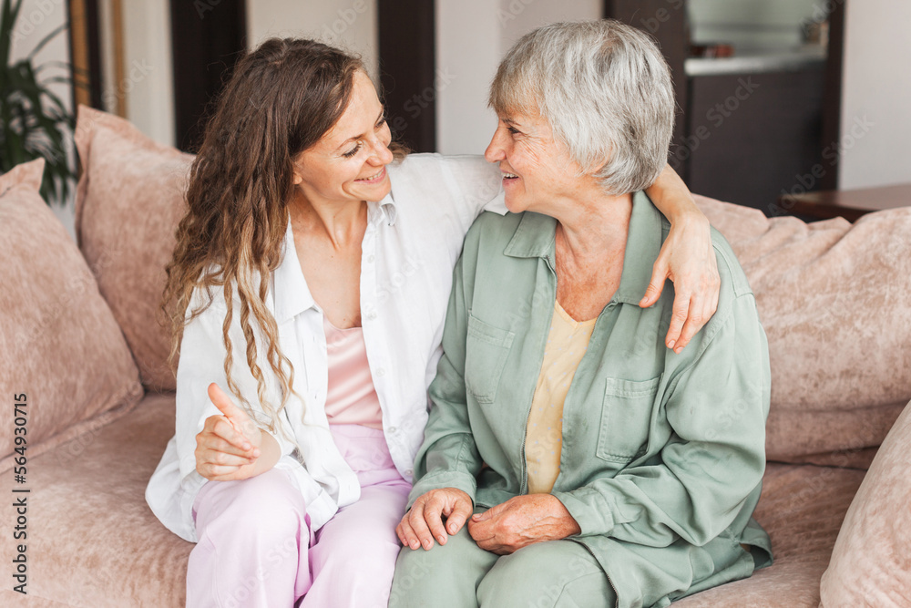 Older mature mother and grown millennial daughter laughing embracing ...