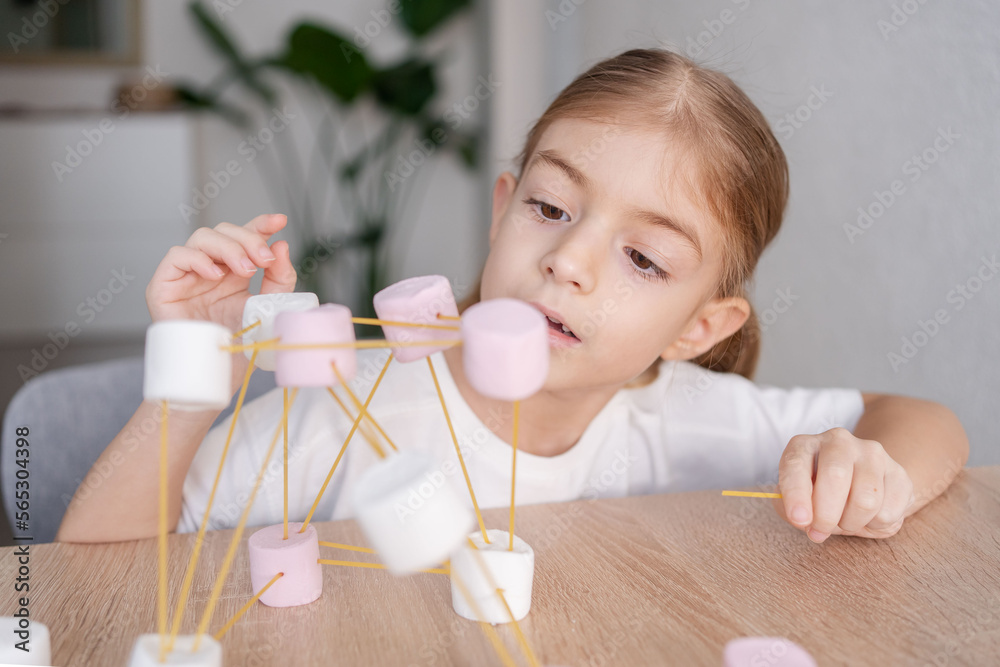 Little girl having fun time learning molecular structure. Concentrated ...