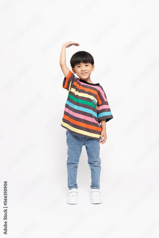 Happy Asian little boy pose to measure your own height, Looking at ...