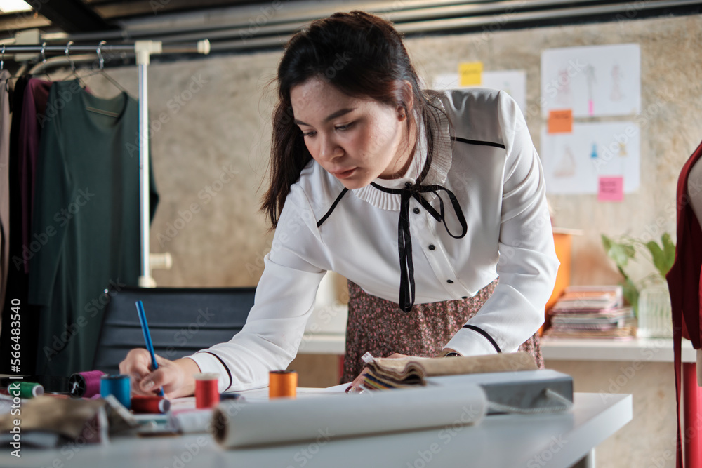 Asian Thai young teenage female fashion designer works in studio by ...