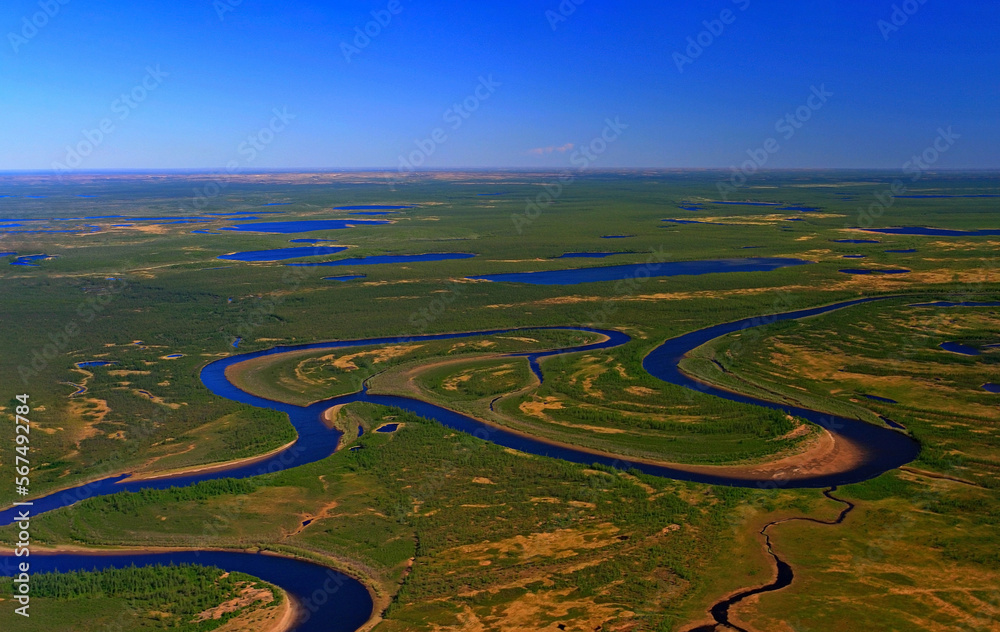 Northern lowland tundra with swamps, lakes and river meanders in spring ...