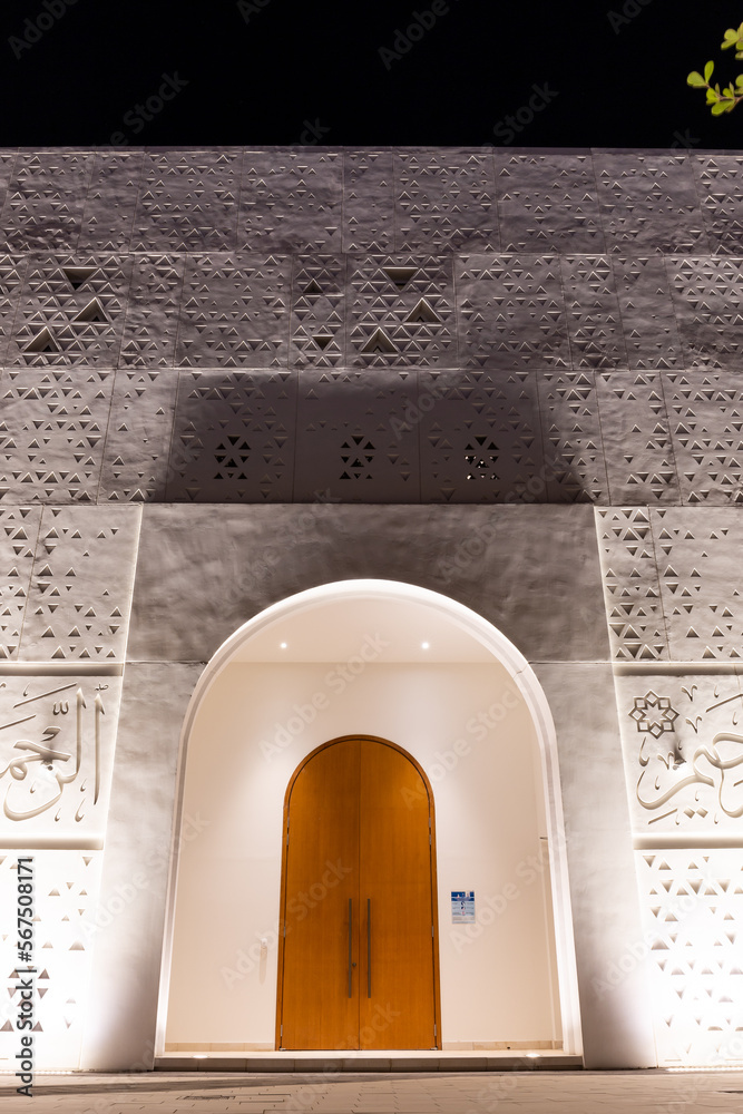 Illuminated entrance doors and facade of white Mosque of Light in Dubai ...