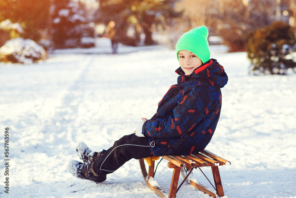 Boy with broken hand outdoors in winter park. Cute kid with broken arm ...