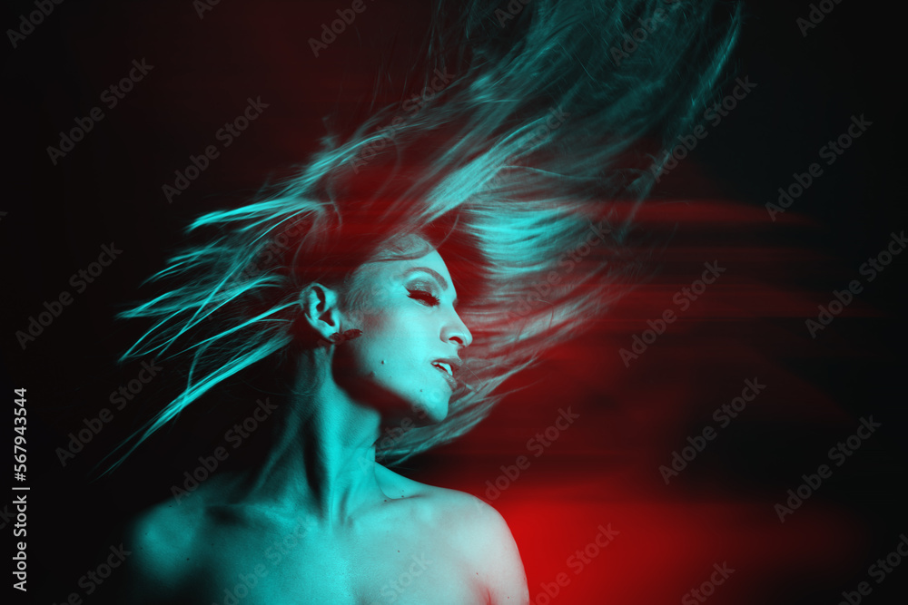 Fashion concept. Portrait of beautiful woman with flying hair in red ...