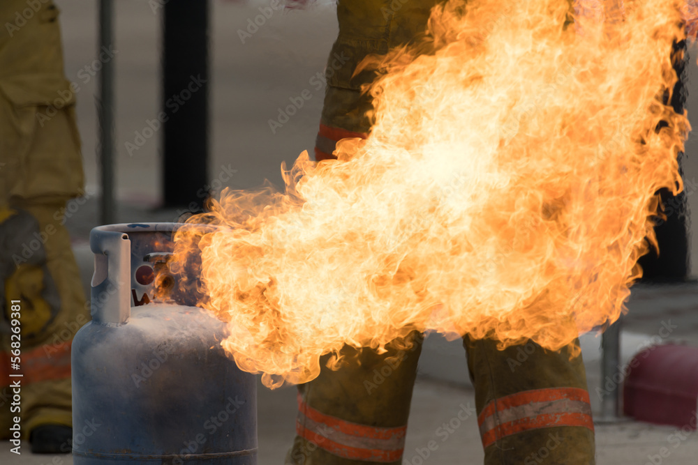 Showing how to use a fire extinguisher on a training fire for employees ...