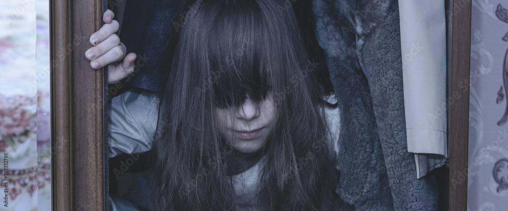 Mad scary girl in cupboard at dark night. Horror background with child ...