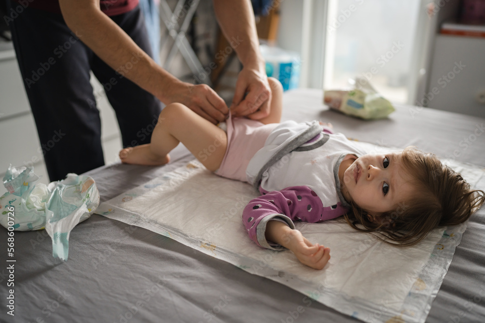 man caucasian father change diapers to his daughter toddler in bedroom ...