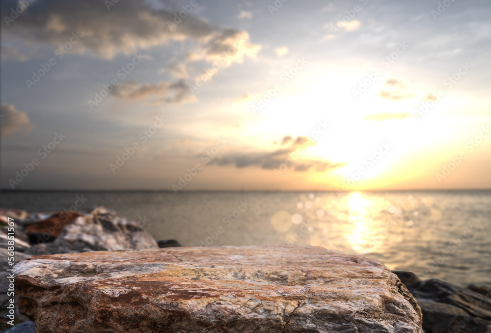 Rock stone stage in nature with sea beach seashore landscape and sunset ...