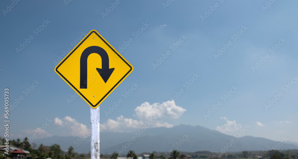 Traffic sign: Right U-turn sign on cement pole beside the rural road ...