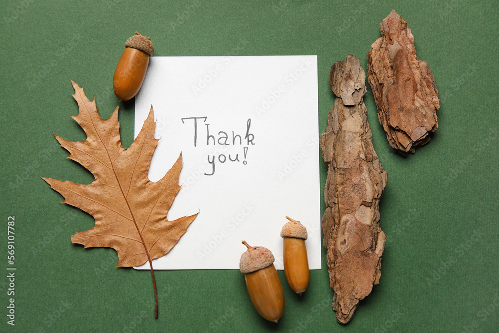 Paper sheet with text THANK YOU, acorns, leaf and tree bark on green ...