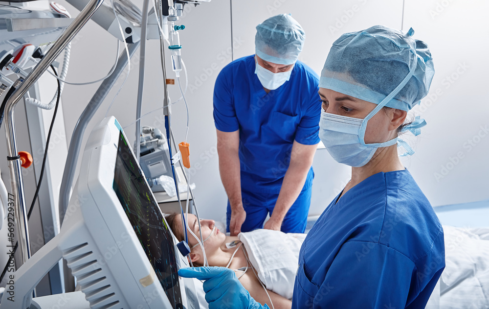 Nurses in intensive care unit of hospital checking vitals of ...
