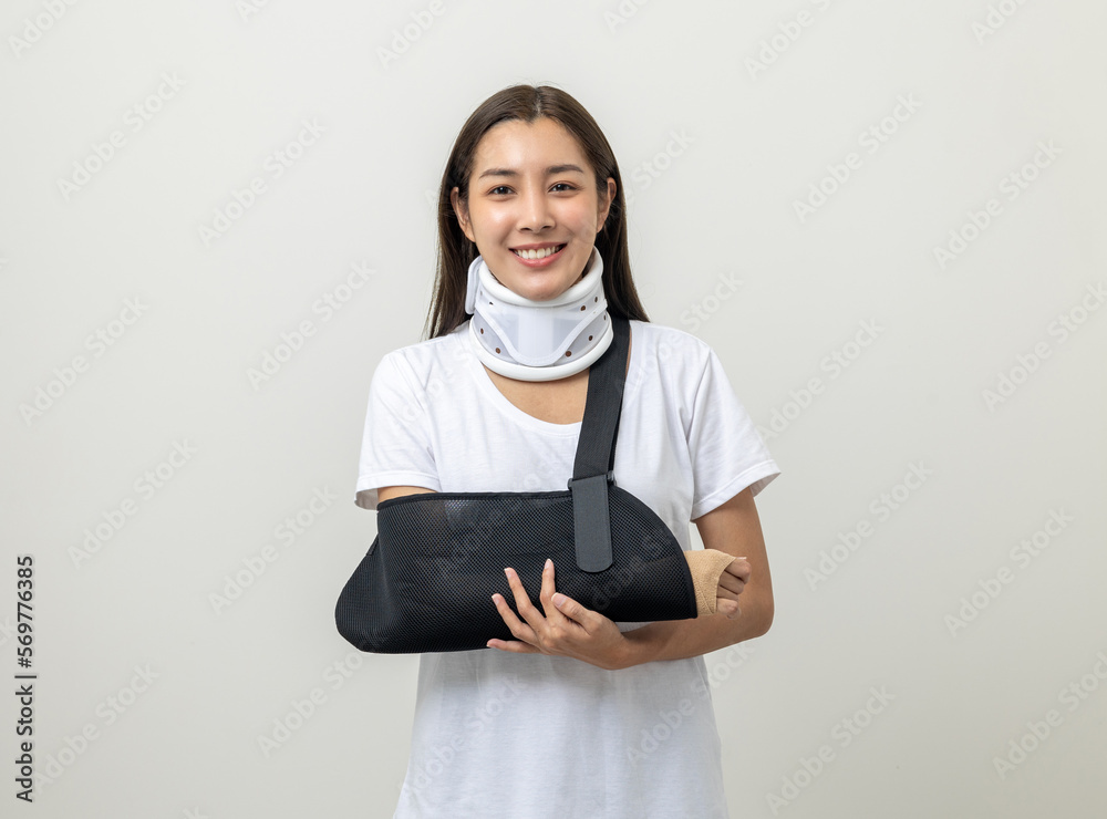 Happy young asian woman broken arm on isolated background. Asian female put on plaster bandage ...