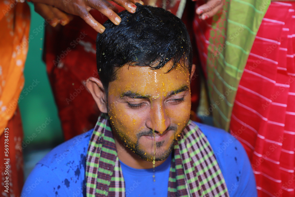 Hindu religious asian groom having bath by her aunts in his pre wedding ...