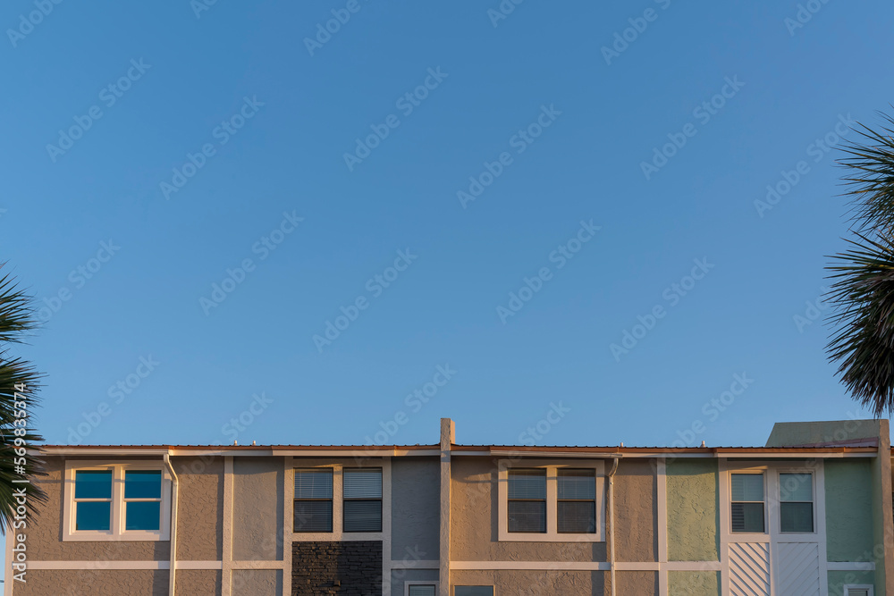 Adjacent box homes creating a straight line from clear sky above in ...