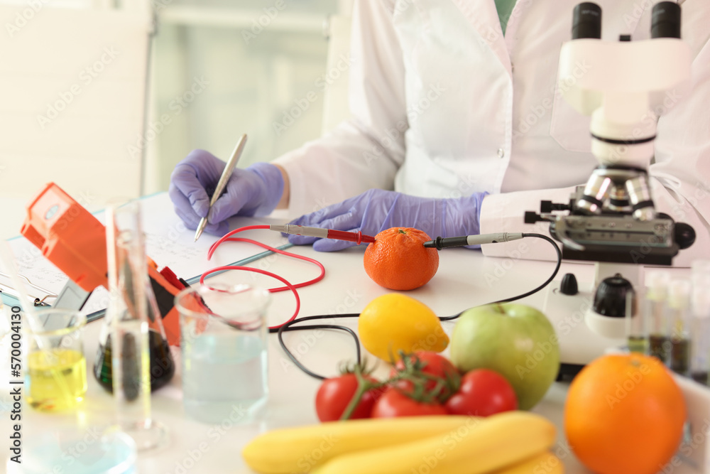 Scientist with microscope and research equipment takes notes while ...