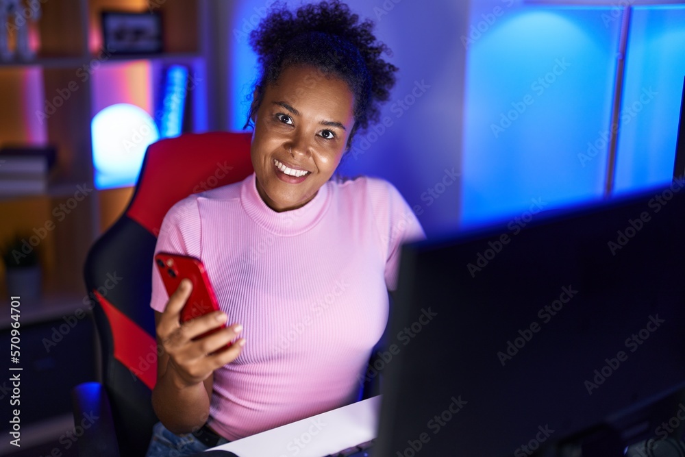 African american woman streamer using computer and smartphone at gaming ...