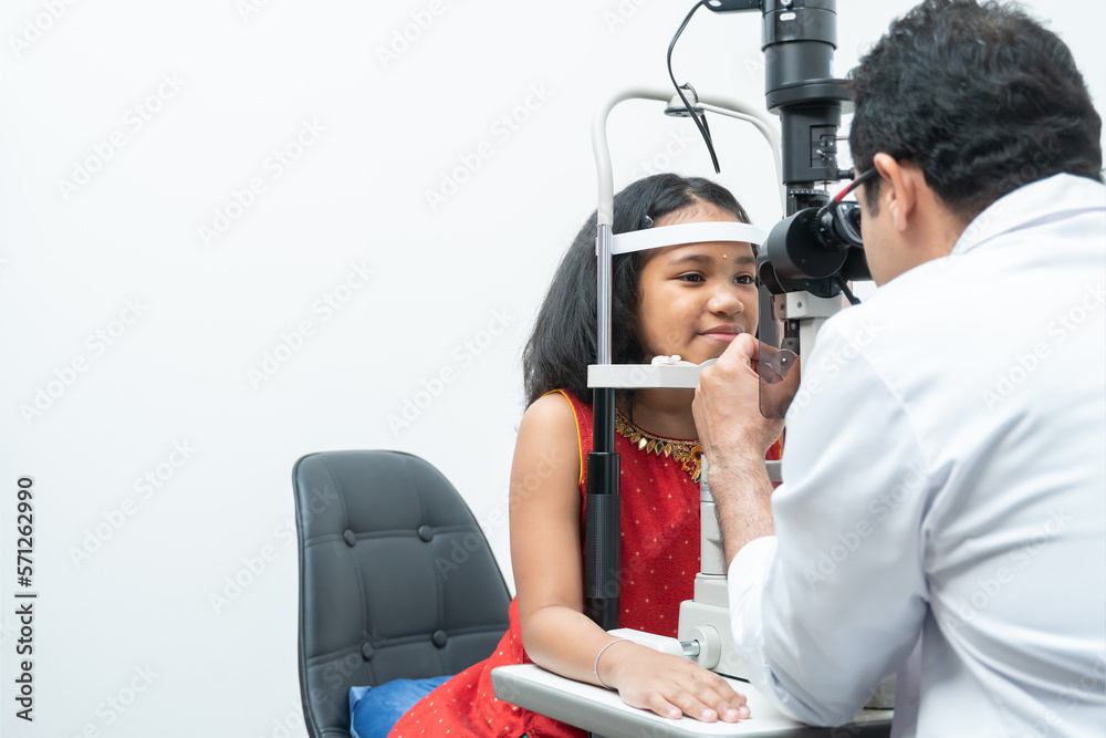 little cute Indian girl child patient is getting eyes exam from ...