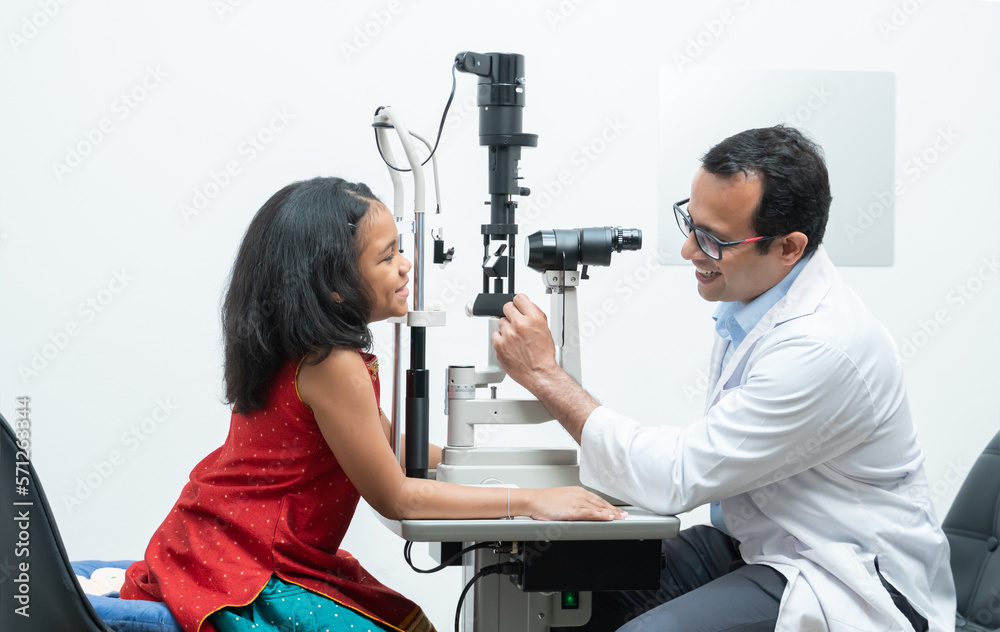 Indian middle aged professional ophthalmologist or optometrist man work ...