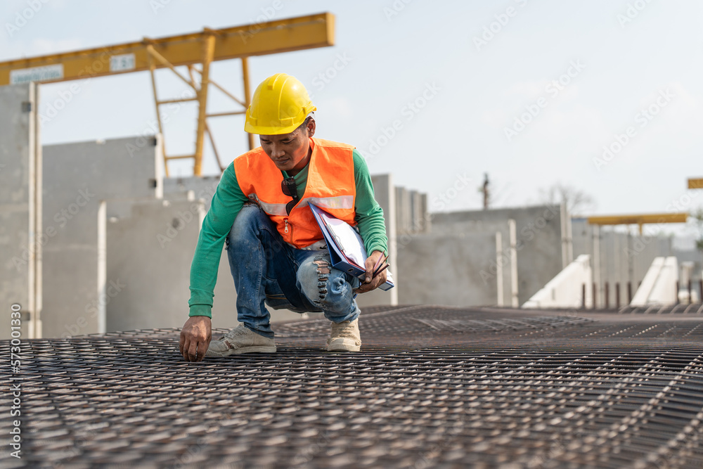 Asian foreman checking steel reinforcement cage for making precast ...
