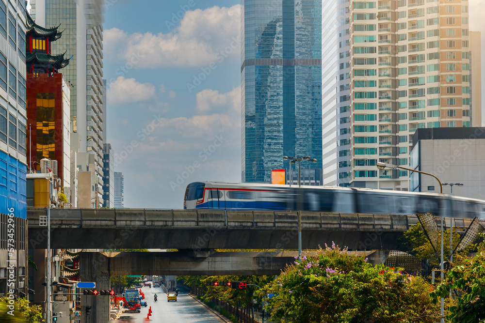 BTS Skytrain, an electric train on a track with office buildings in the ...