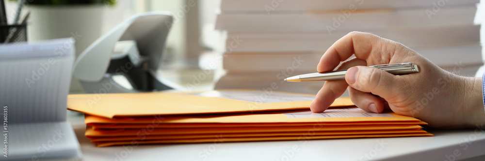 Person fill in the address on yellow envelope of postal correspondence ...