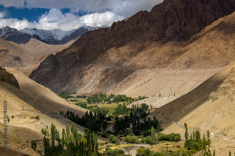 Beautiful play of light on the valley of Basgo, snow capped Himalayan ...