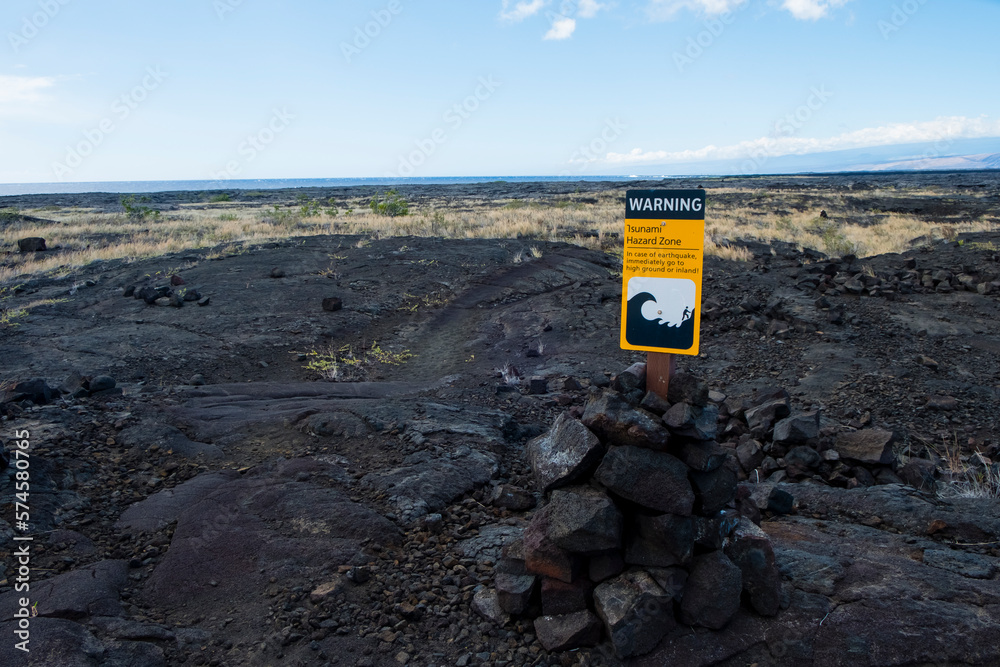 Tsunami warning sign in coastal volcanic landscape, Puna Coast Trail ...