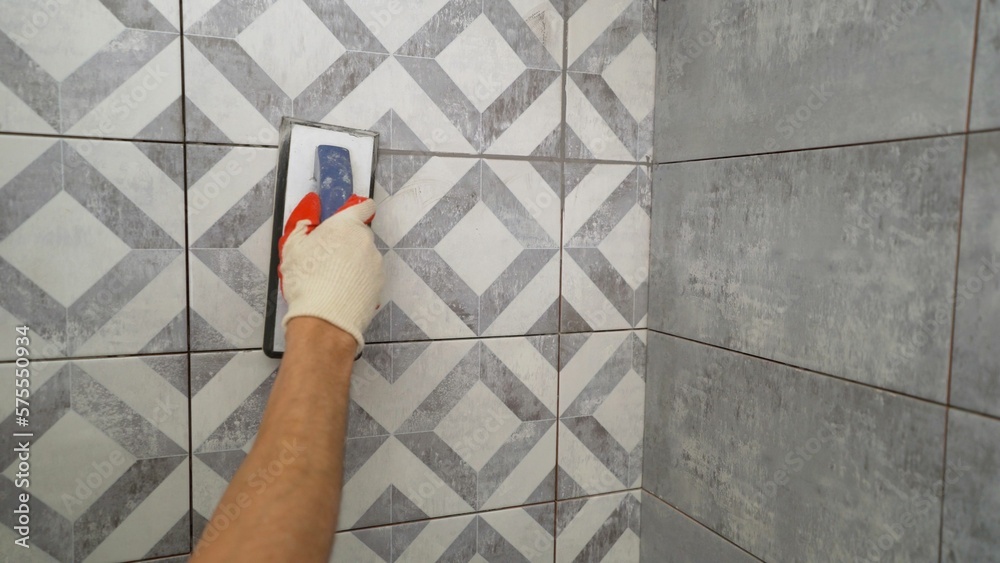Black grout for tiles. laying ceramic tiles. Tilers fill the spaces ...