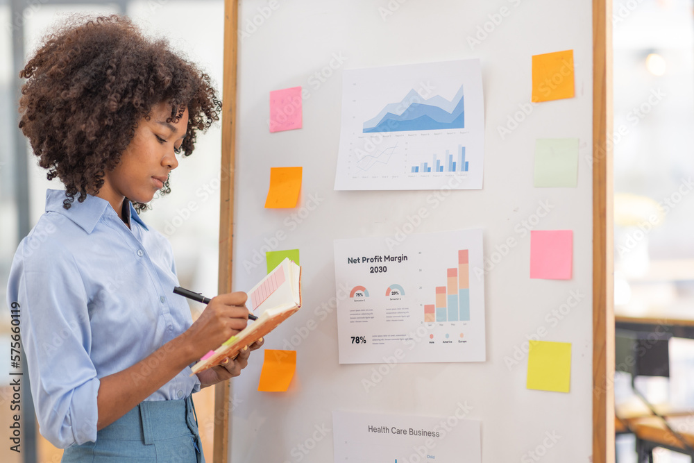 young asian entrepreneur of small company putting a adhesive sticky ...