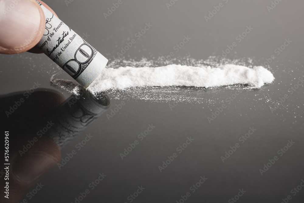 Snorting cocaine, white powder line, rolled up dollar bill, black ...