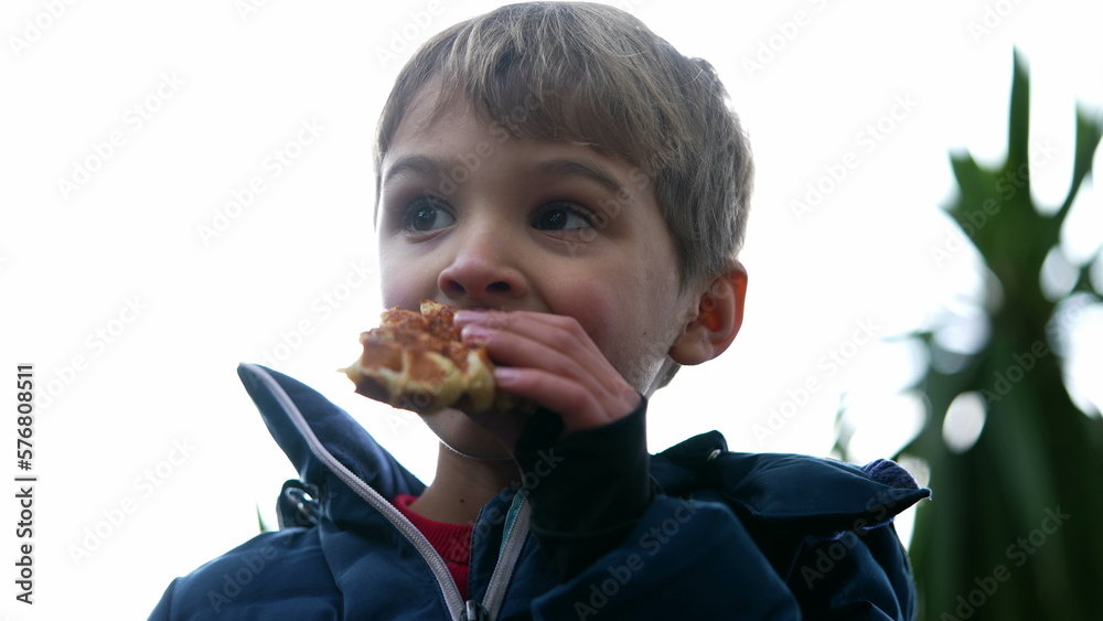 Child eating Belgum waffle outdoors. Little boy enjoying chocolate ...