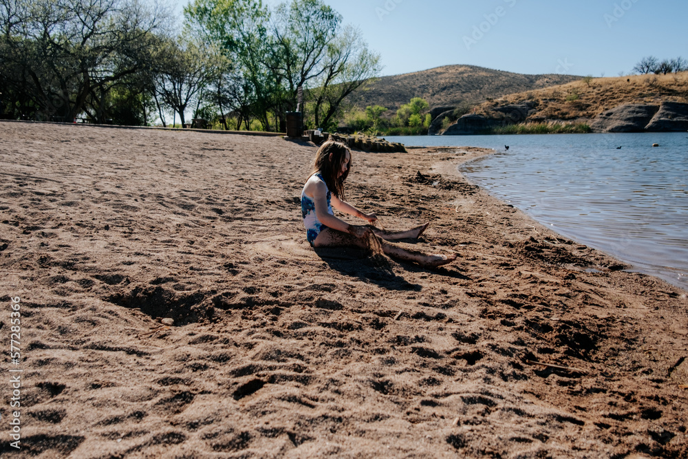 Tween girl playing in sand at a lake Stock Photo | Adobe Stock