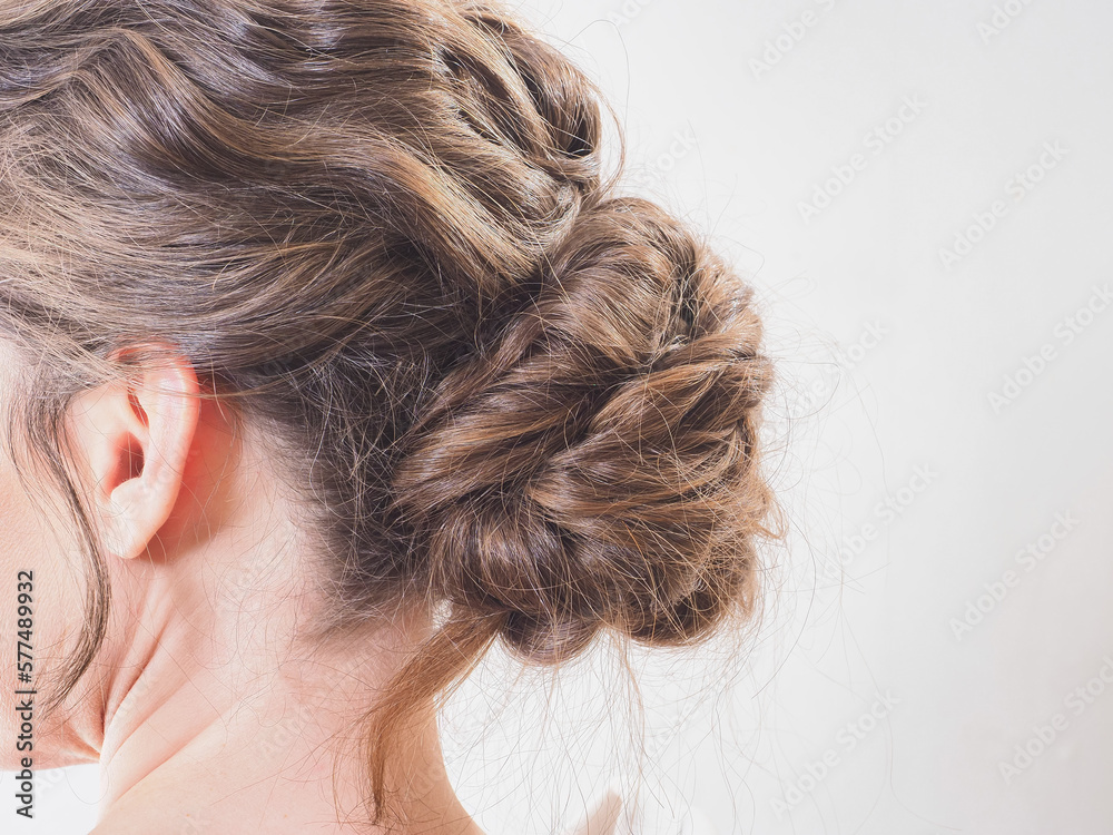 Photo Stock A beautiful girl gathered her wavy hair in a low bundle ...