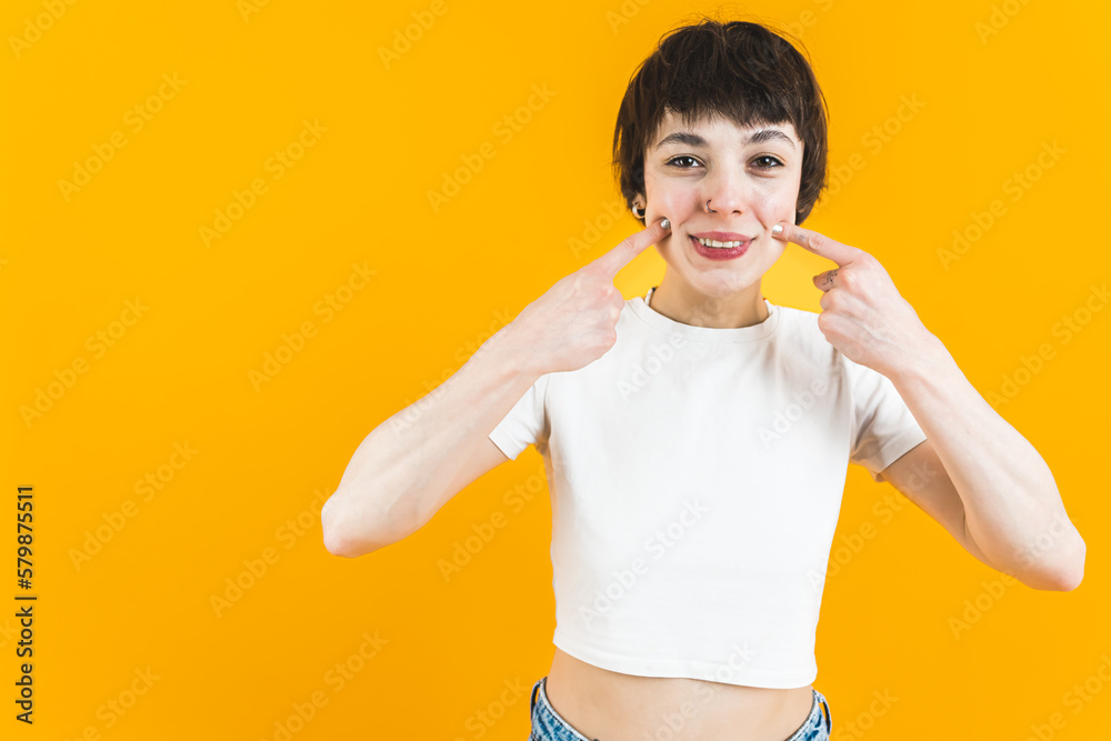 Cropped-hair woman in white top smiling hesitantly slightly and putting ...