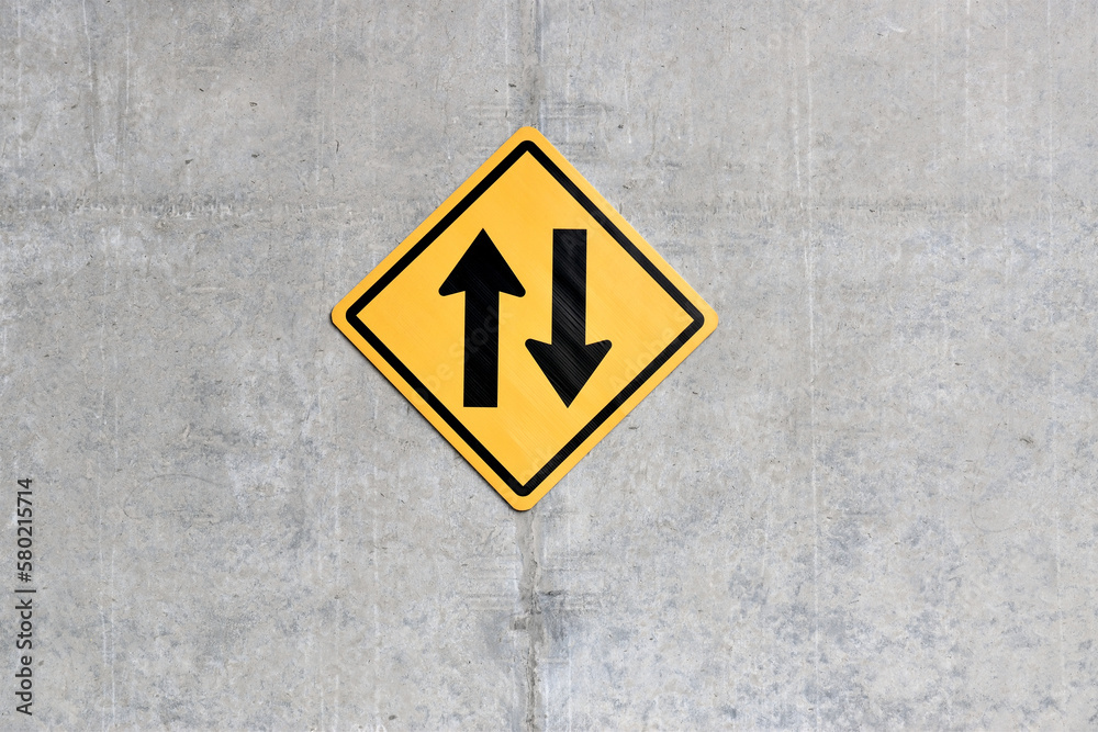 up and down arrows on yellow square diamond traffic sign hanging on ...