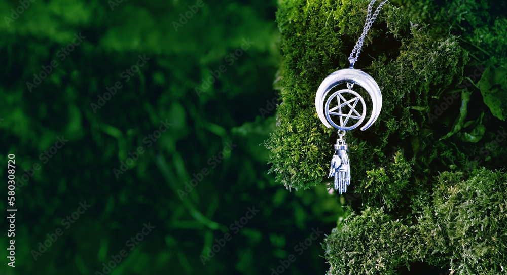 amulet with pentagram on moss, abstract natural dark forest background ...