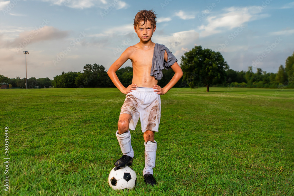 Hot and sweaty young soccer player posing with shirt off after soccer ...
