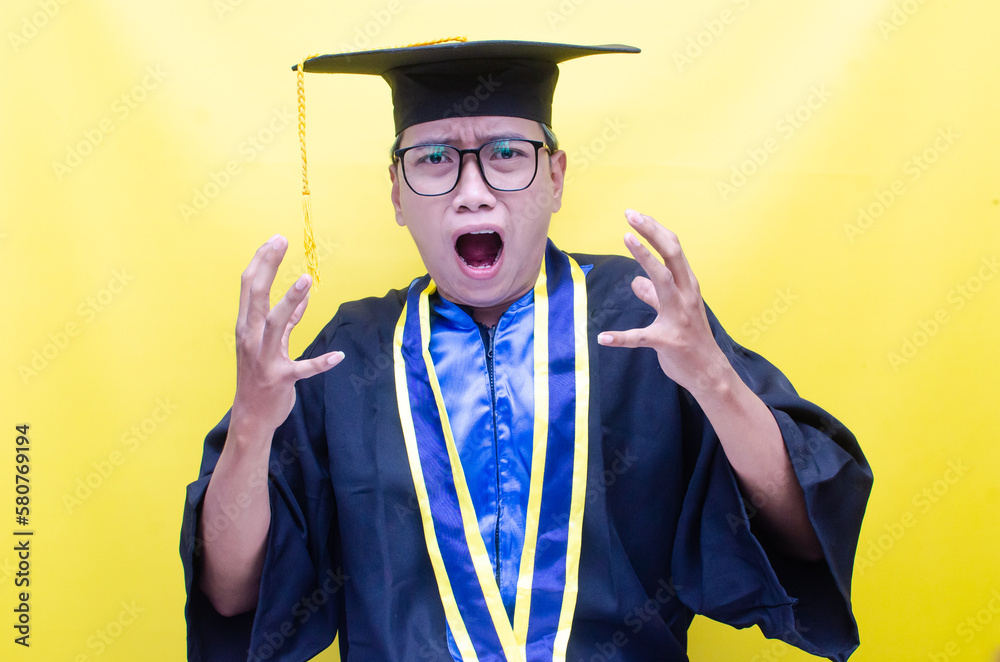 angry Asian man in graduation cap and gown shouting madly and showing ...