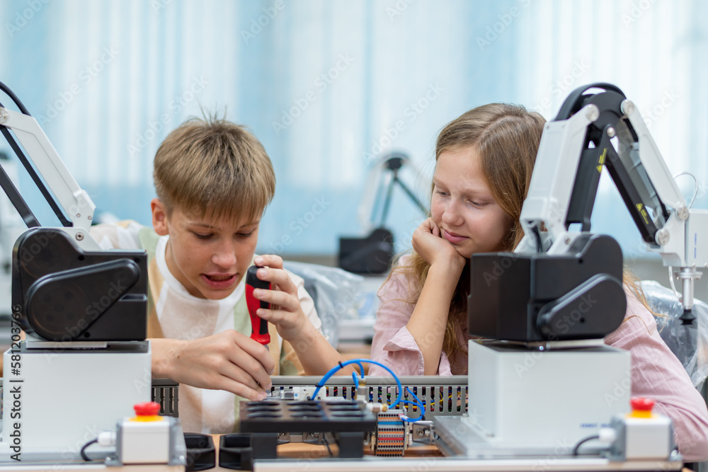 Group Kid teen child enjoy Machine Learning Robot arm is Moving Under coding Control robot at ...
