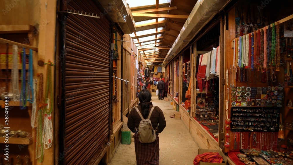 People walking inside the narrow shopping passage in Thimphu, Bhutan ...