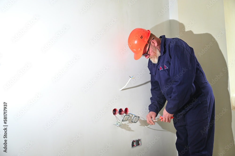 Professional electrician technician installing a wall socket in a new ...