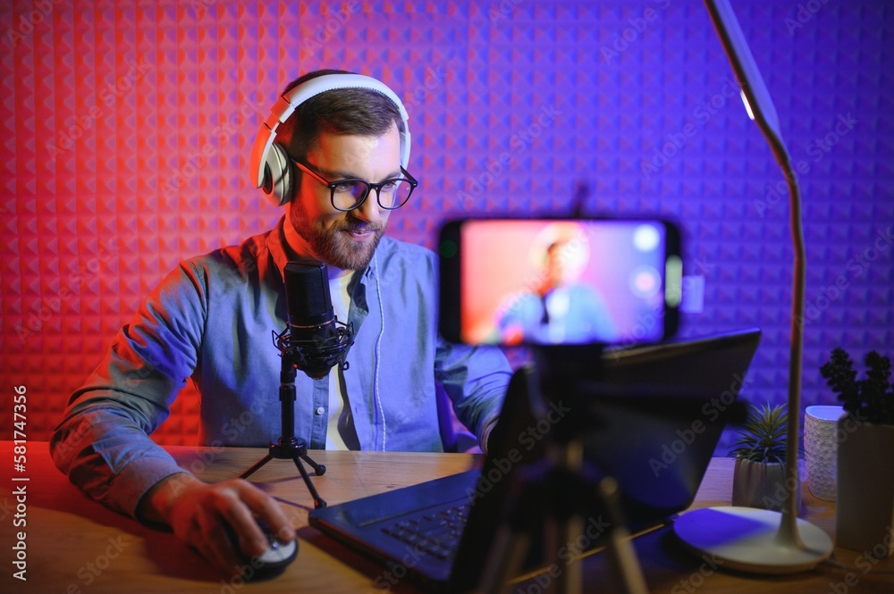vlogger using smartphone to film podcast in studio. blogger with mobile ...