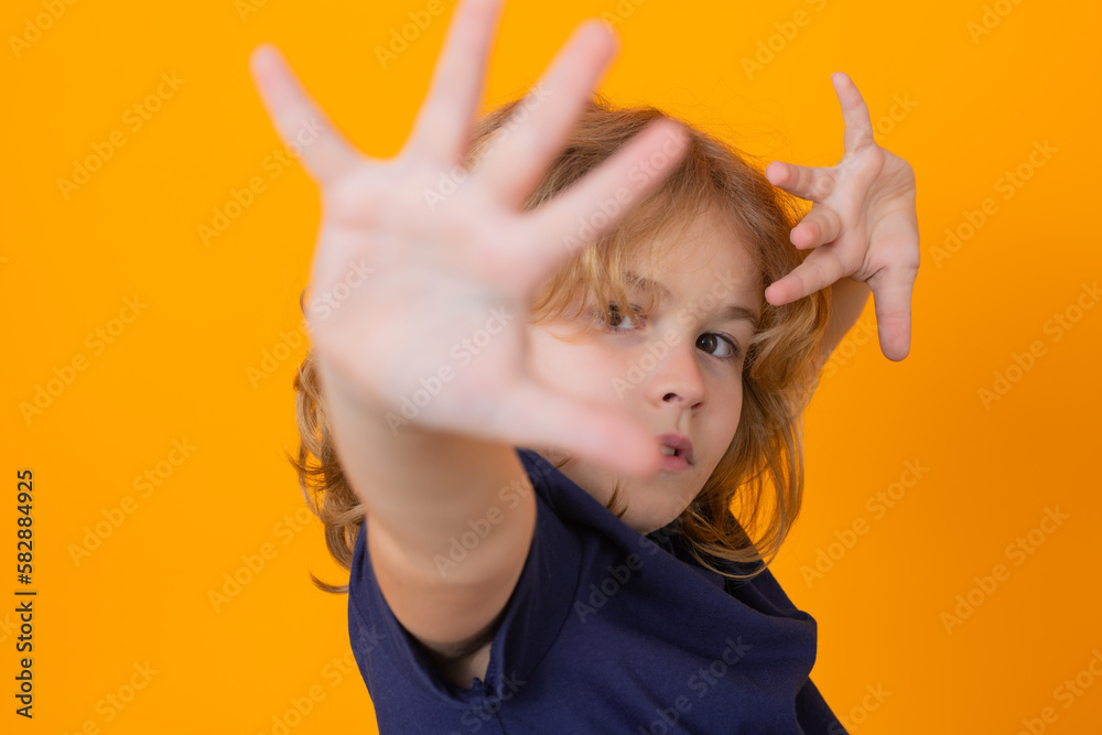 Child making stop gesture on yellow isolated studio background. Kid ...