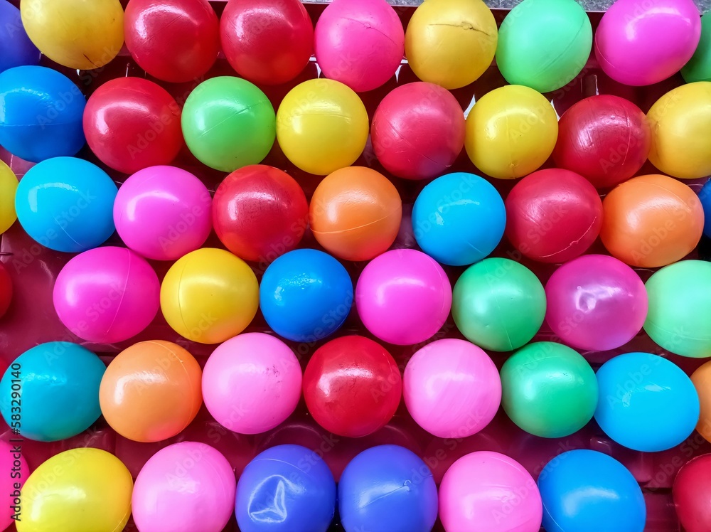 Top view of multicolor plastic balls in a container for toys and ...