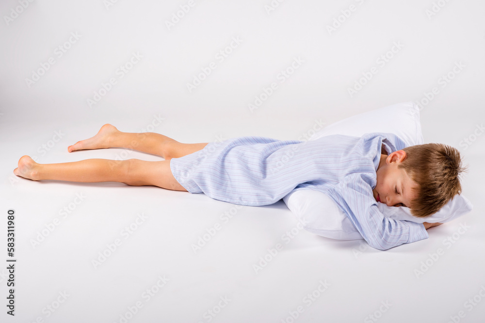Young preteen boy wearing pajamas sleeping on the floor with pillow Stock Photo | Adobe Stock