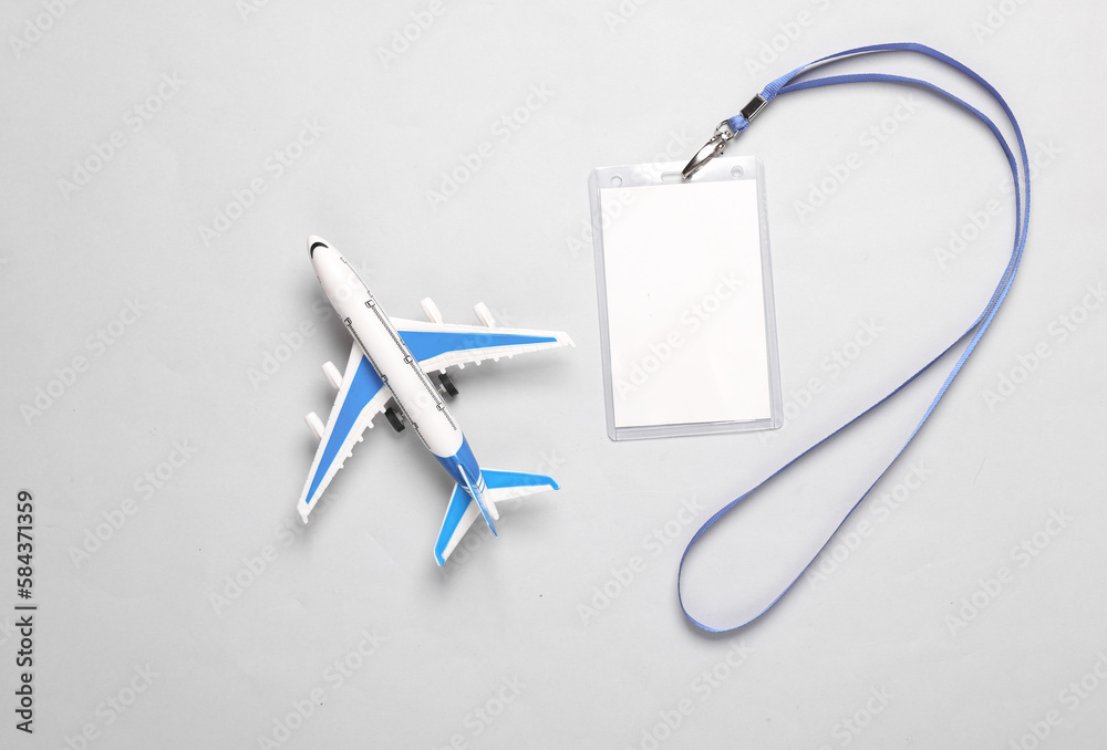 Toy air plane and empty white ID card badge mockup on gray background ...